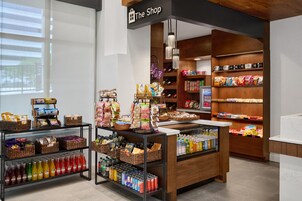 Uma loja com prateleiras cheias de lanches, bebidas e uma vitrine com garrafas.