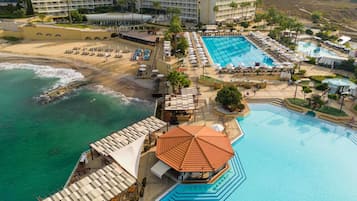Resort com várias piscinas, área de praia e um amplo complexo de edifícios.