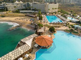 Resort com várias piscinas, área de praia e um amplo complexo de edifícios.