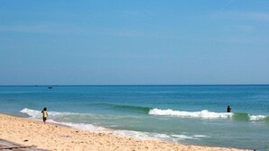 Uma praia com areal arenoso e mar calmo.