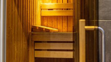 Uma sauna com bancos de madeira e porta de metal.