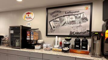 Espaço de buffet de café da manhã com um letreiro Superstart, um letreiro de boas-vindas emoldurado para Lafayette, Indiana, e diversos dispensadores de alimentos e bebidas.