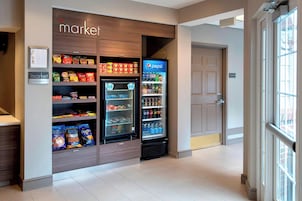 Espaço com máquinas de venda automática de lanches e bebidas, incluindo um refrigerador de Pepsi.