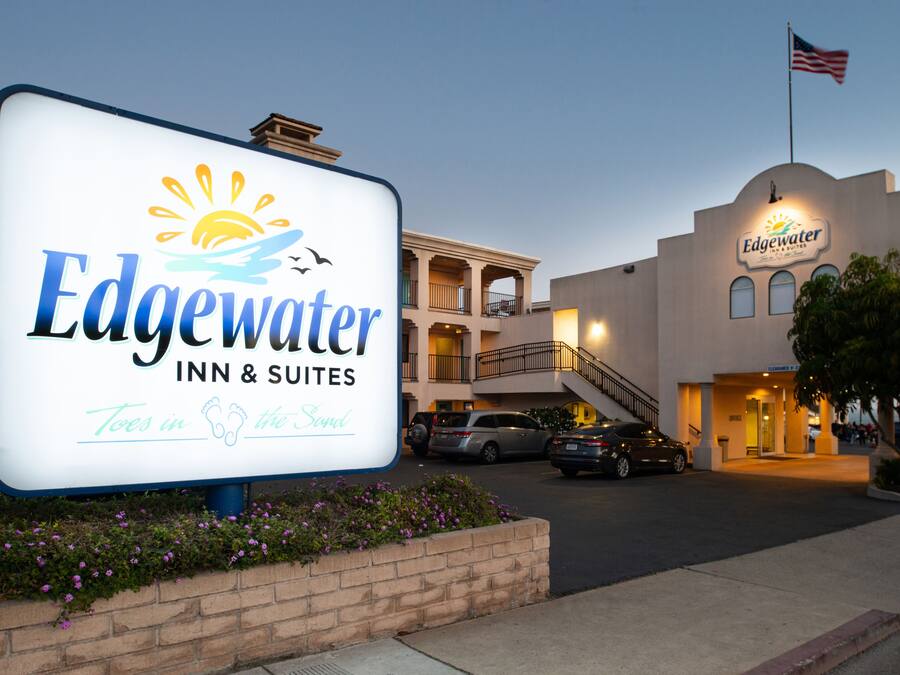 Placa de hotel do Edgewater Inn & Suites, com vista clara da entrada do edifício e estacionamento.