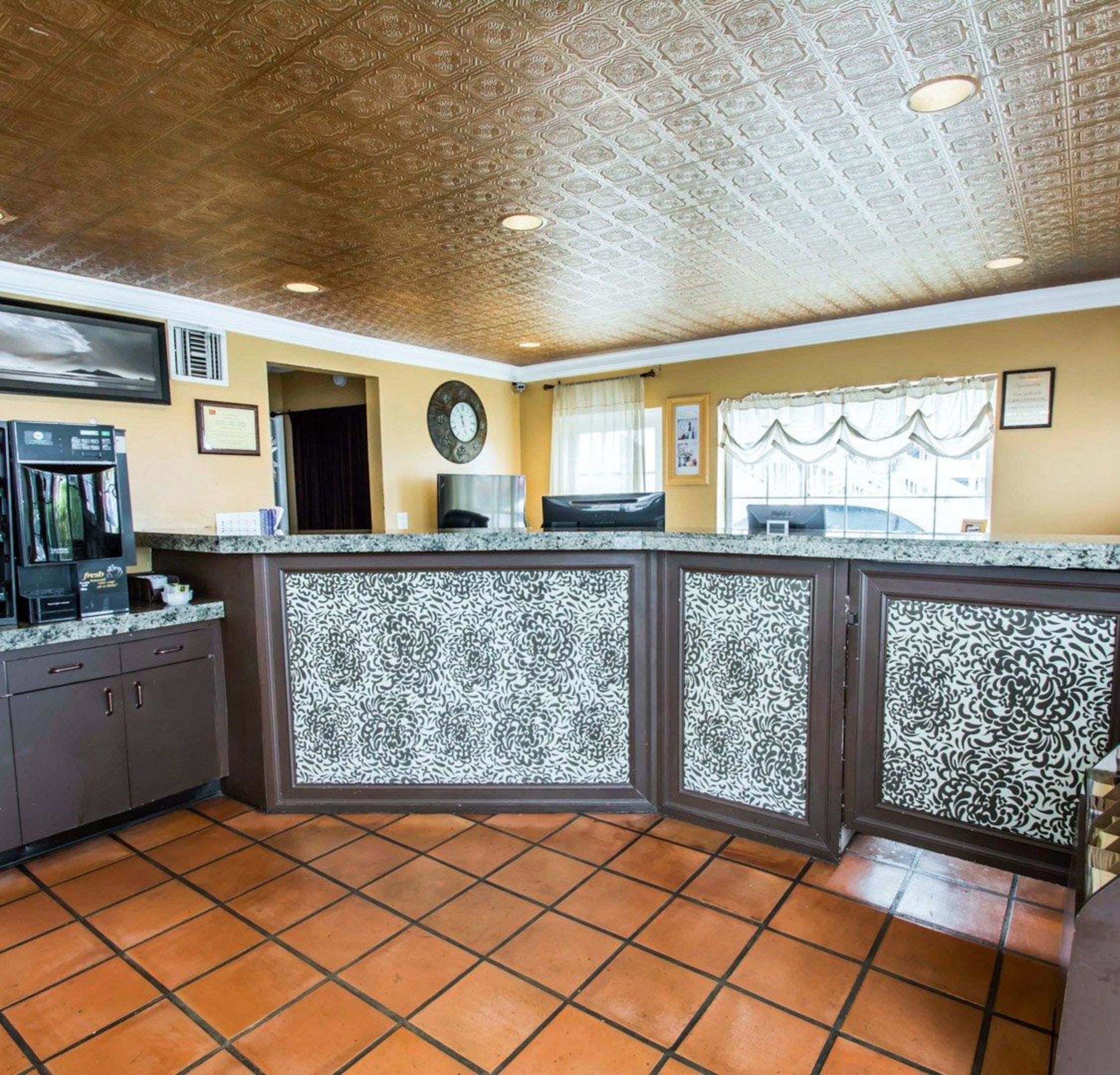 Cozinha com piso de azulejos, geladeira embutida, micro-ondas e máquina de café.