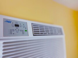 Unidade de ar condicionado com painel de controle que inclui termostato, modo dormir e configurações de temporizador.