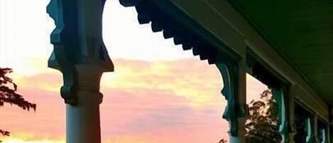 Uma varanda com vista para o pôr do sol sobre o mar.