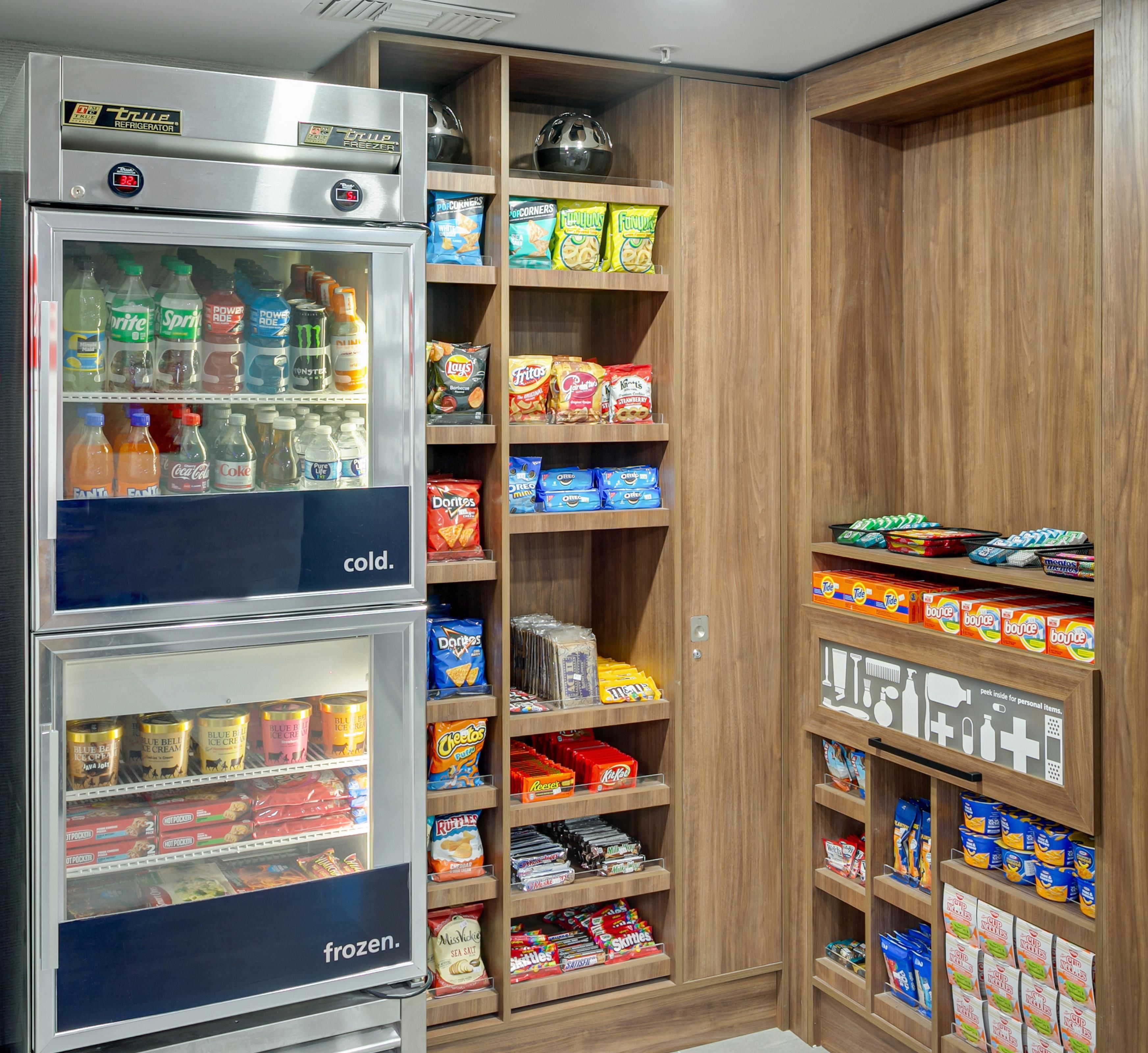 Máquina de vendas com diversos lanches e bebidas, incluindo refrigerantes e sorvetes.