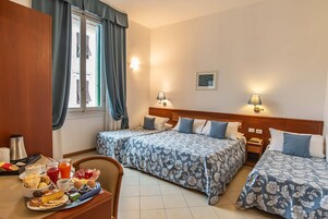 Quarto de hotel com duas camas, bandeja de café da manhã, cafeteira e janela com cortinas.