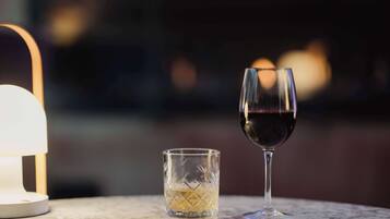 Um copo de vinho tinto e um pequeno copo com bebida sobre uma superfície de mármore.