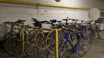 Uma área de estacionamento para bicicletas com várias bicicletas presas a um suporte amarelo.