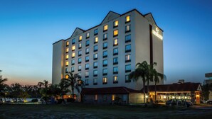 Um hotel com vários andares, teto plano e um grande letreiro na lateral.