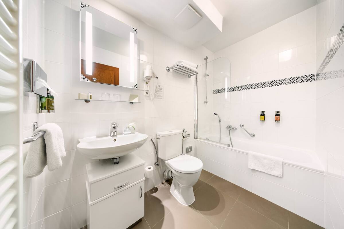 Uma casa de banho moderna com lavatório, sanita e chuveiro.