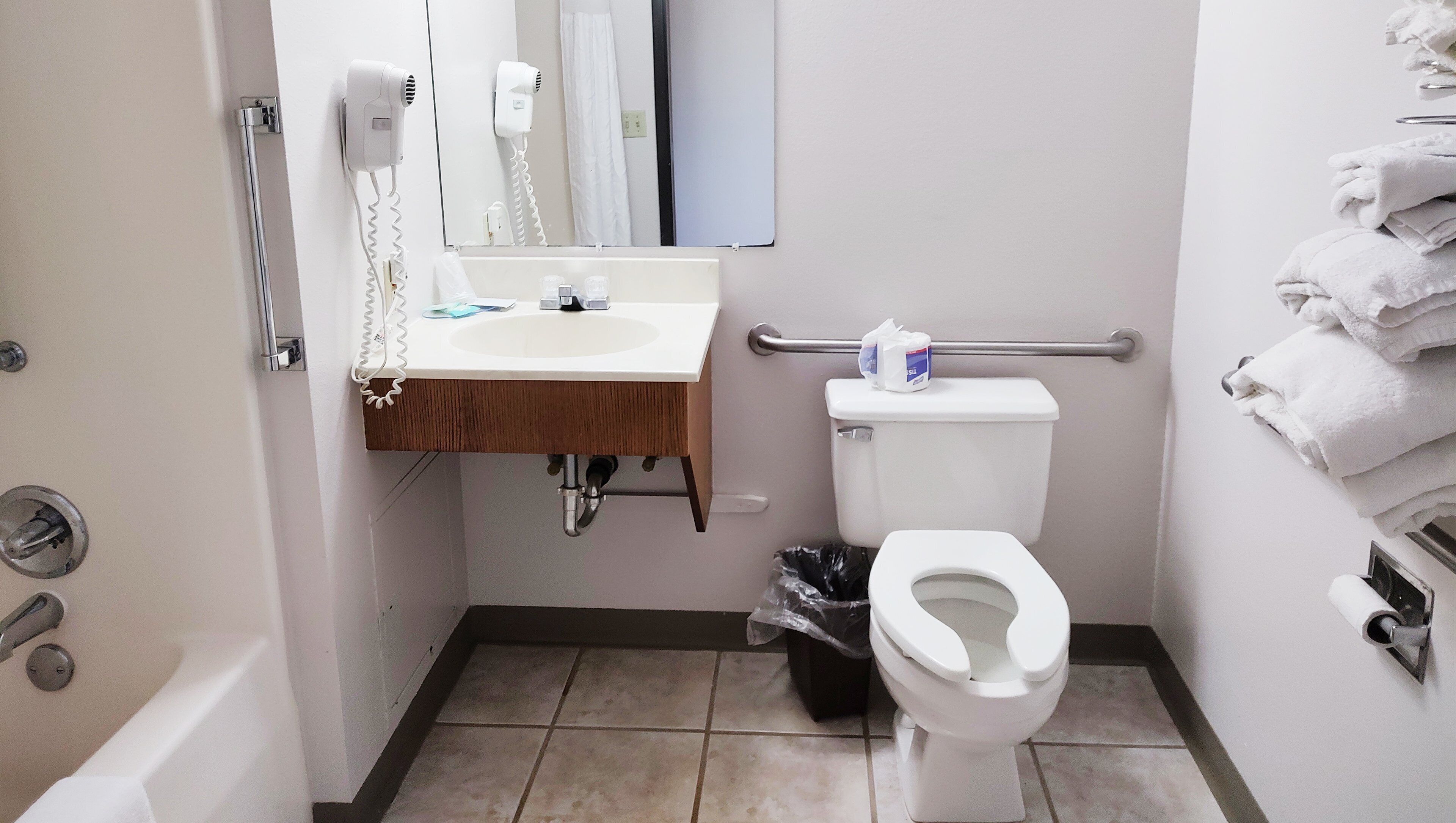 Casa de banho compacta com lavatório branco, espelho e sanita.