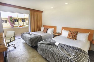 Quarto de hotel com duas camas, uma escrivaninha e uma cadeira.