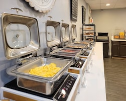 Uma mesa de buffet com vários distribuidores de comida para autoatendimento.
