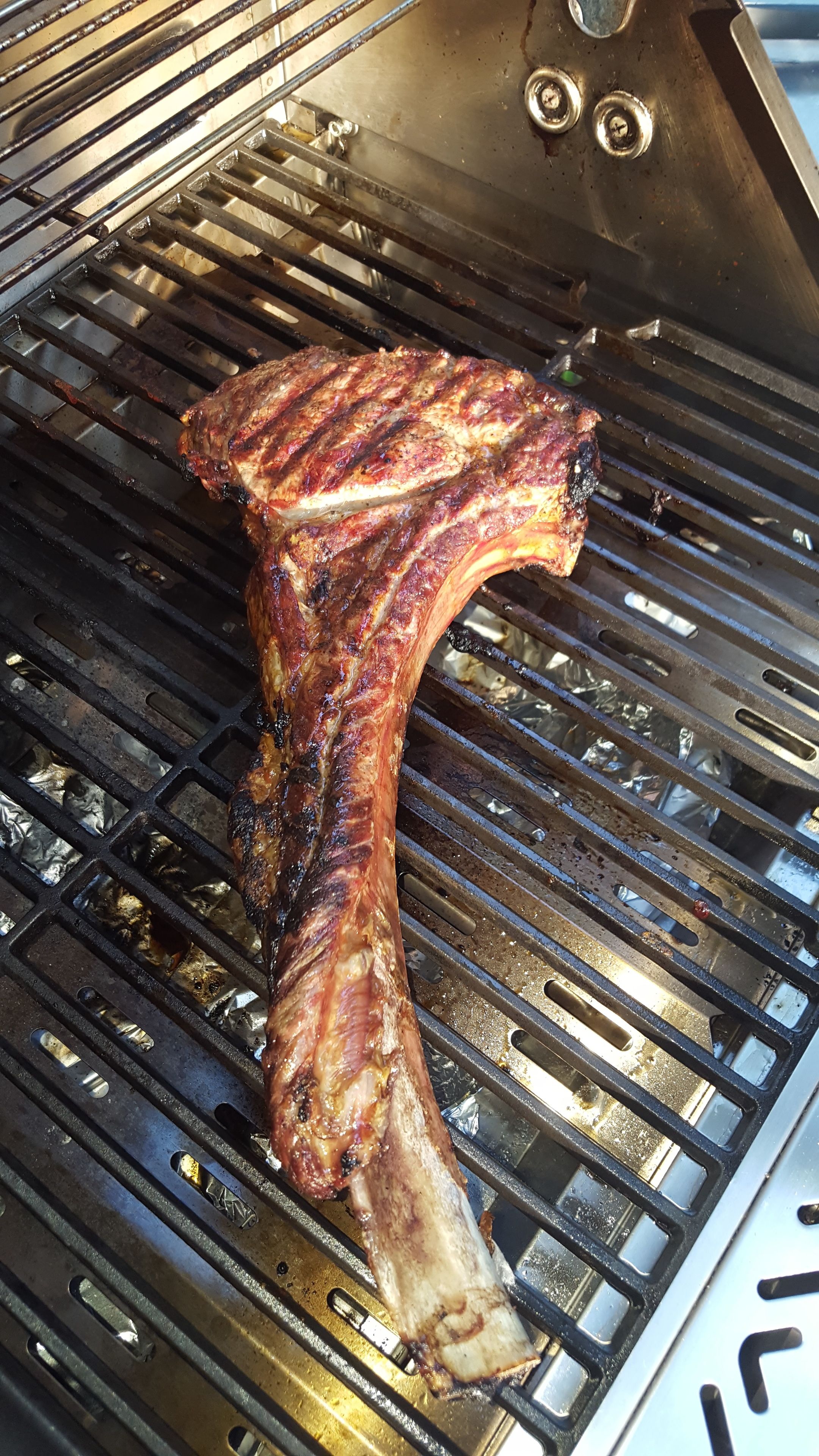 Uma grande porção de carne assando numa grelha de metal.