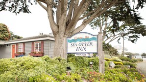 Placa do Sea Otter Inn com um jardim na frente.