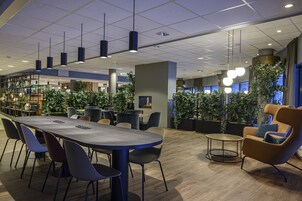 Uma sala de conferências moderna com uma mesa comprida, várias cadeiras e uma pequena mesa de centro.