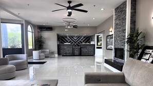 Uma sala de estar moderna com lareira, ventilador de teto e uma grande janela.