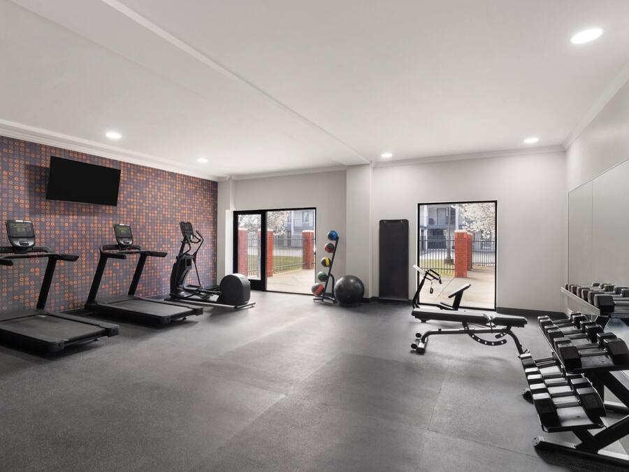 Uma academia com esteiras, bolas de exercício e máquinas de musculação.