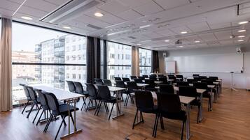 Uma sala de conferências com mesas e cadeiras dispostas para uma reunião.