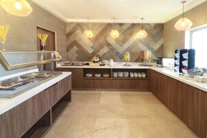 Uma cozinha moderna com serviço de buffet, incluindo diversas opções de comida e um espaço para café.