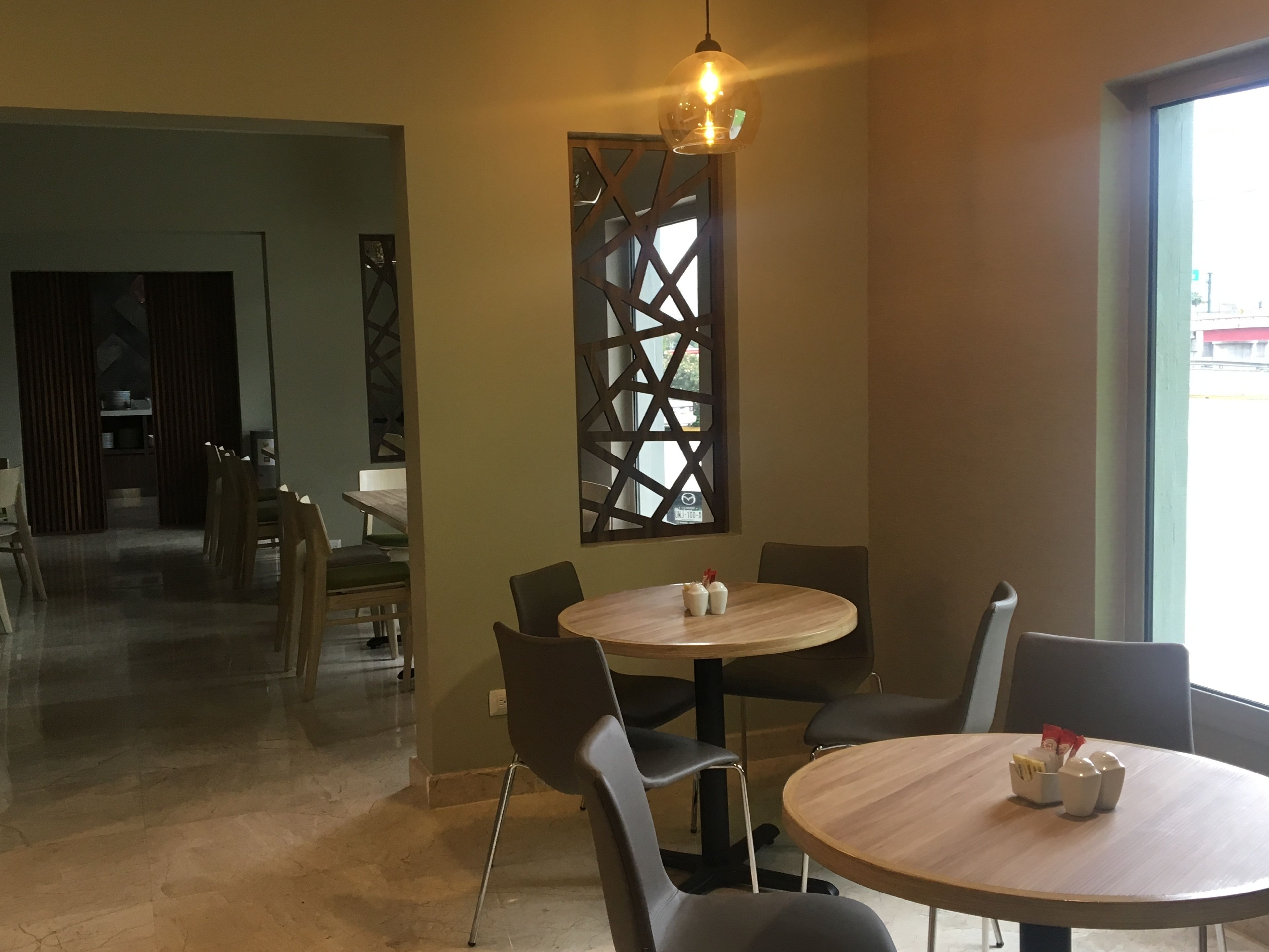 Uma sala de jantar moderna com uma mesa redonda, cadeiras e um painel decorativo.