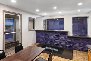 Quarto de hotel moderno com área de refeições, uma janela grande e vista para o exterior.