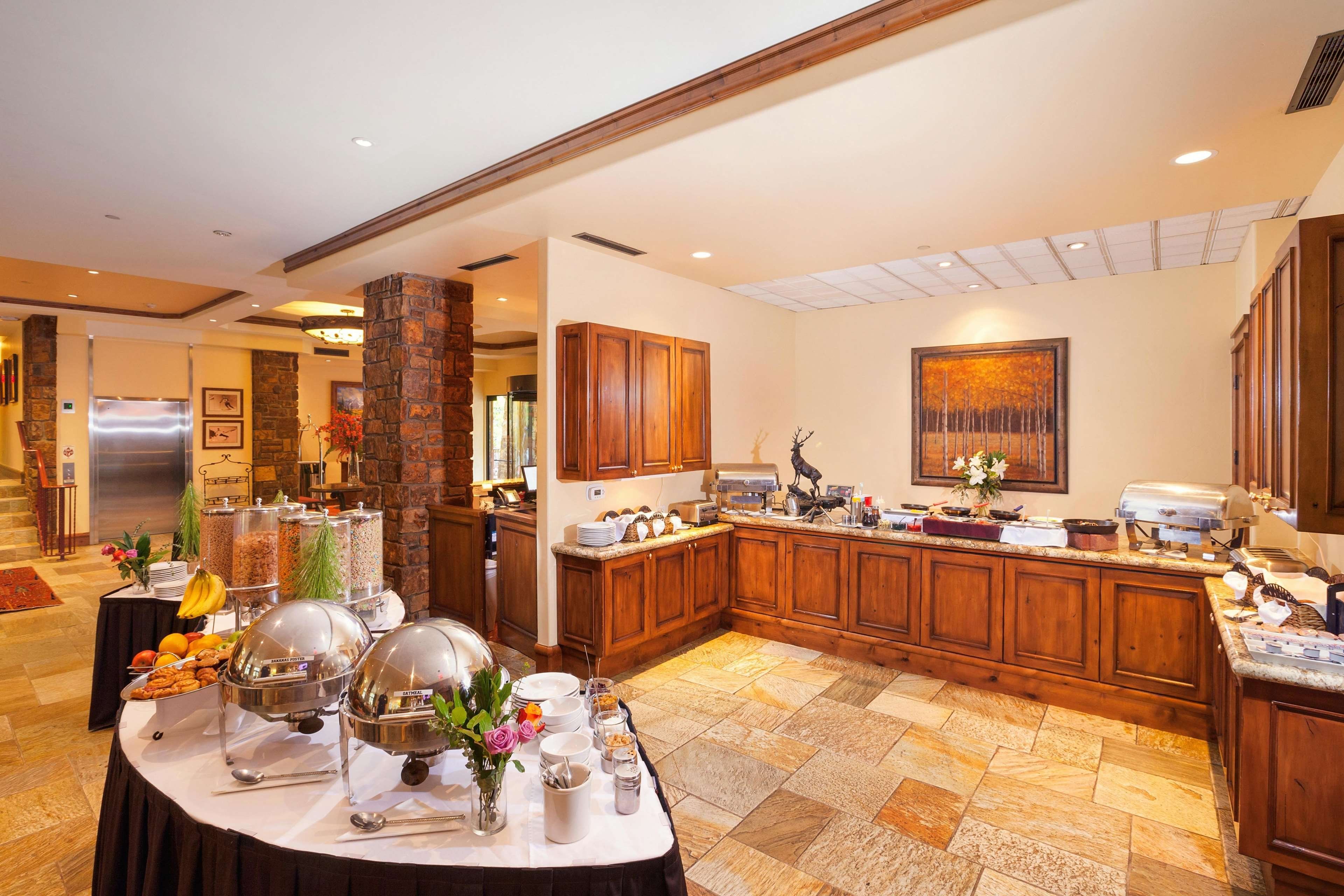 Cozinha ampla com armários de madeira, bancada de granito e serviço de buffet para café da manhã.