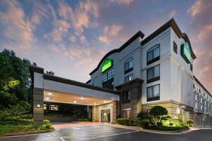 Um hotel com design moderno, entrada coberta e estacionamento.