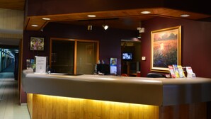 Uma receção com design em painel de madeira, um relógio e um quadro emoldurado na parede.