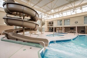 Piscina interior com tobogã e banheira de hidromassagem.