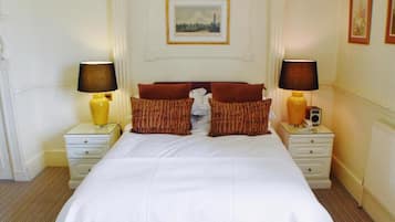 Quarto de hotel bem arrumado com uma cama grande, duas mesas de cabeceira com abajures e um quadro na cabeceira.