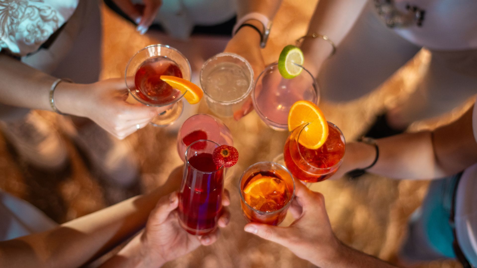 Um grupo de pessoas segurando diferentes bebidas com guarnições.
