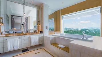 Casa de banho moderna com um espelho grande, duas pias, uma banheira e vista para a cidade.
