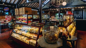 Uma padaria com diversos produtos de panificação expostos, incluindo pão e doces.