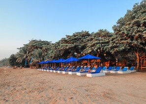 Na praia, espreguiçadeiras, guarda-sóis de praia 