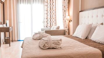Quarto de hotel com uma cama grande, uma escrivaninha e uma cadeira.