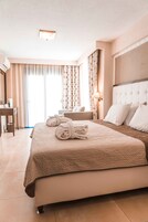 Quarto de hotel com uma cama grande, uma escrivaninha e uma cadeira.