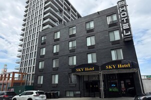 Edifício de hotel com fachada moderna, várias varandas e uma entrada notável com sinalização.