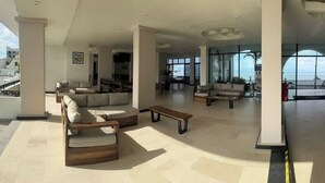 Um hall amplo com vista para a piscina, assentos confortáveis e design moderno.