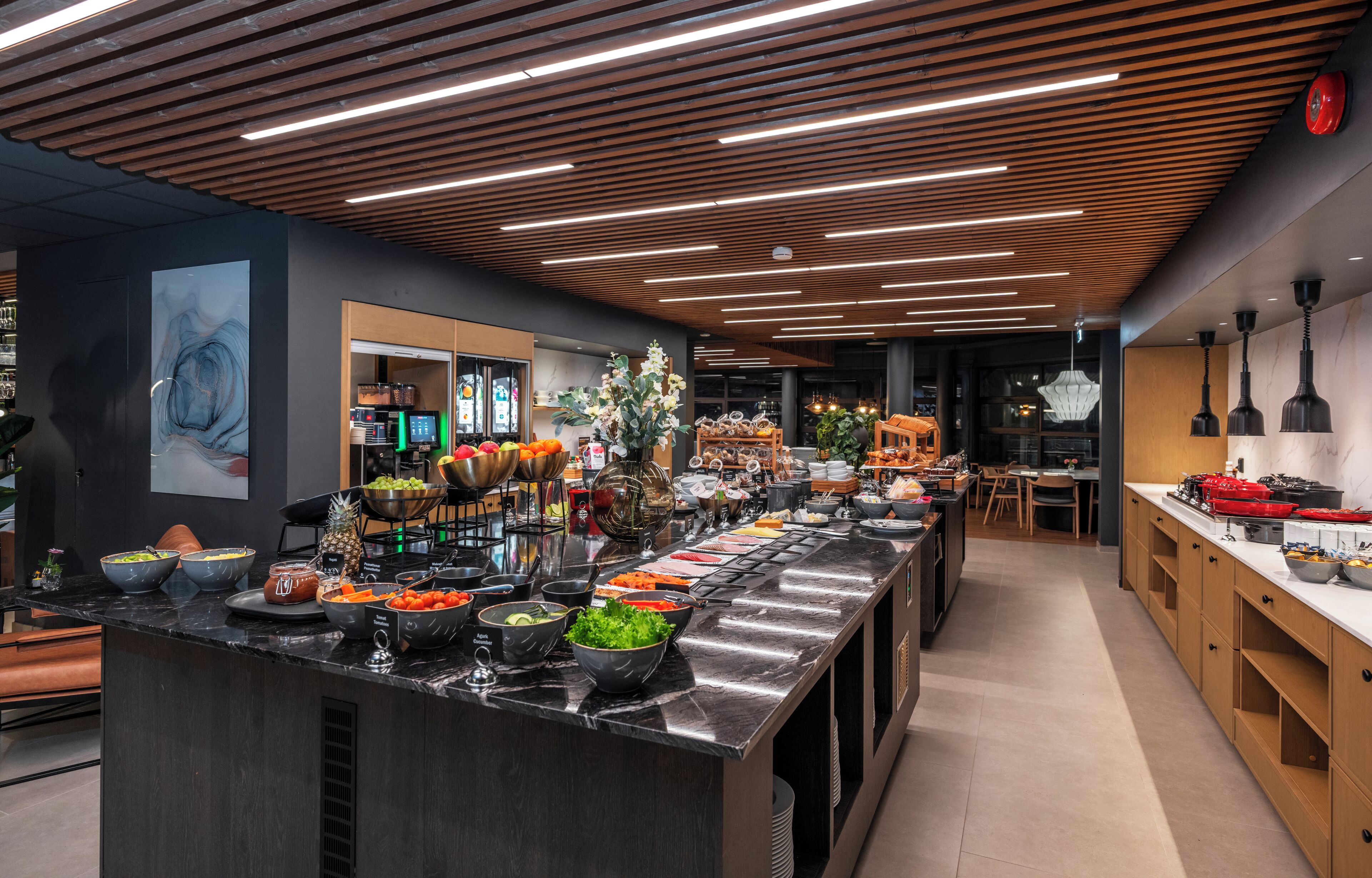 Disposição de buffet com diversos alimentos e design de interiores moderno.