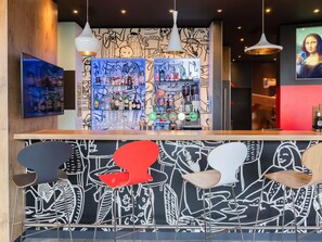 Uma área de bar com design moderno, incluindo um balcão com banquetas, uma parede com arte abstrata e uma grande pintura da Mona Lisa.
