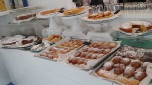 Um buffet com diversos doces e sobremesas, incluindo bolos e pâtisseries à mostra.