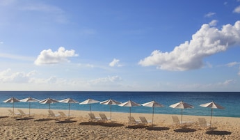 Na praia, praia de areia branca, espreguiçadeiras, guarda-sóis de praia