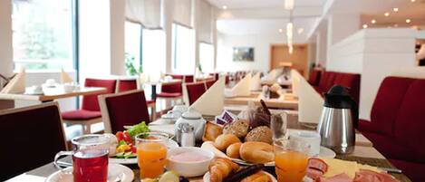 Um buffet de café da manhã com diversas opções de comida e bebidas.