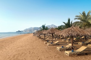 Uma praia privada, espreguiçadeiras, guarda-sóis de praia