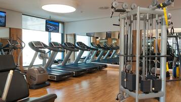 Academia com esteiras, aparelhos de musculação e equipamentos de ginástica.