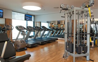 Academia com esteiras, aparelhos de musculação e equipamentos de ginástica.